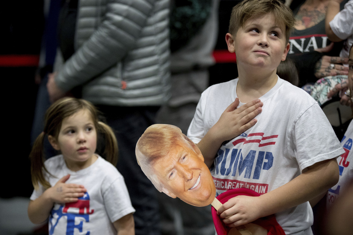 children in the audience stand for the pledge of allegiance before ...