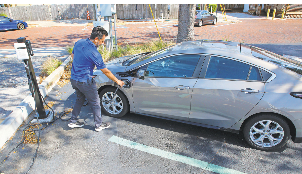 Nick Makris of Port Richey plugs in his Chevy Volt hybrid EV at the ...