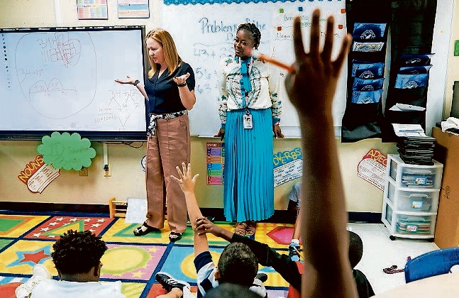 GRACE BEAHM ALFORD/STAFF A math coach works with third-grade teacher ...